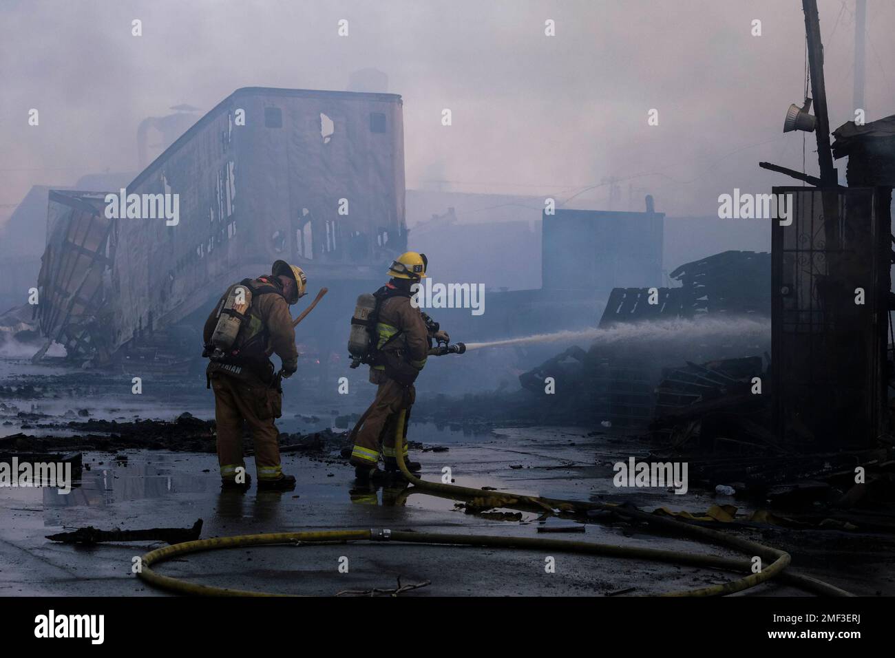 Firefighters battle a fire at a commercial yard in Compton, Calif., on ...