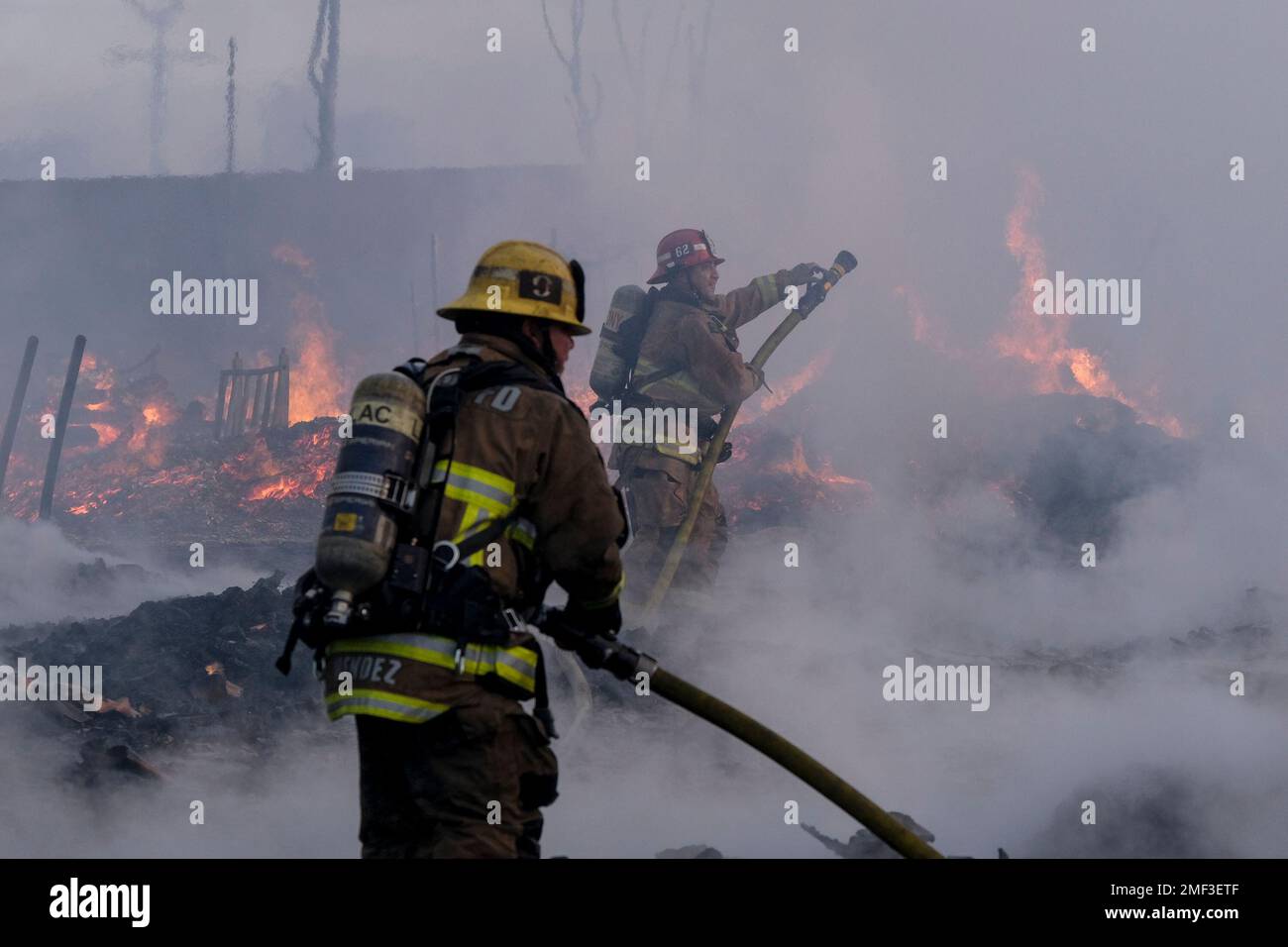Firefighters battle a fire at a commercial yard in Compton, Calif., on ...