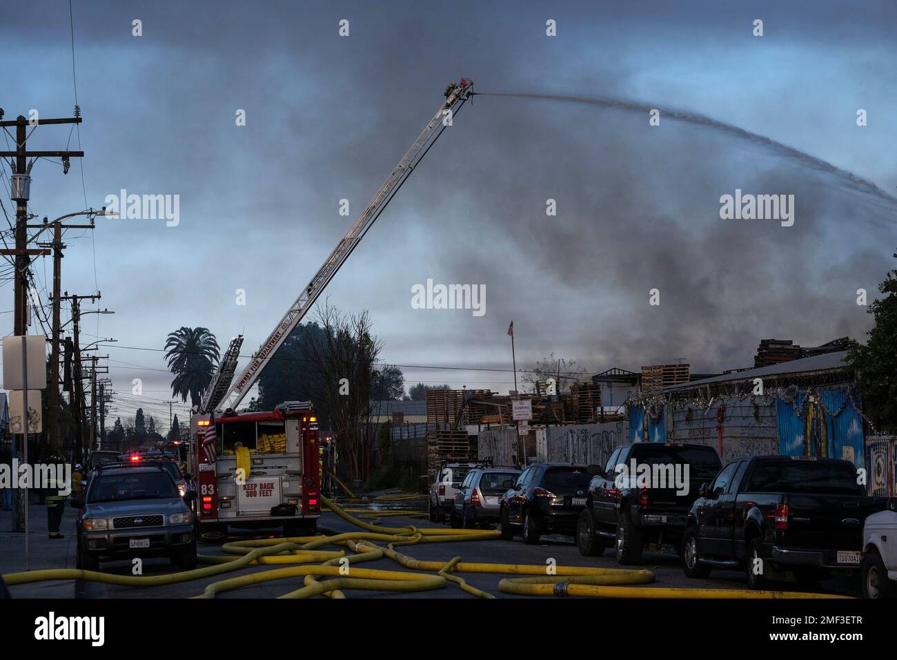 Firefighters battle a fire at a commercial yard in Compton, Calif., on ...