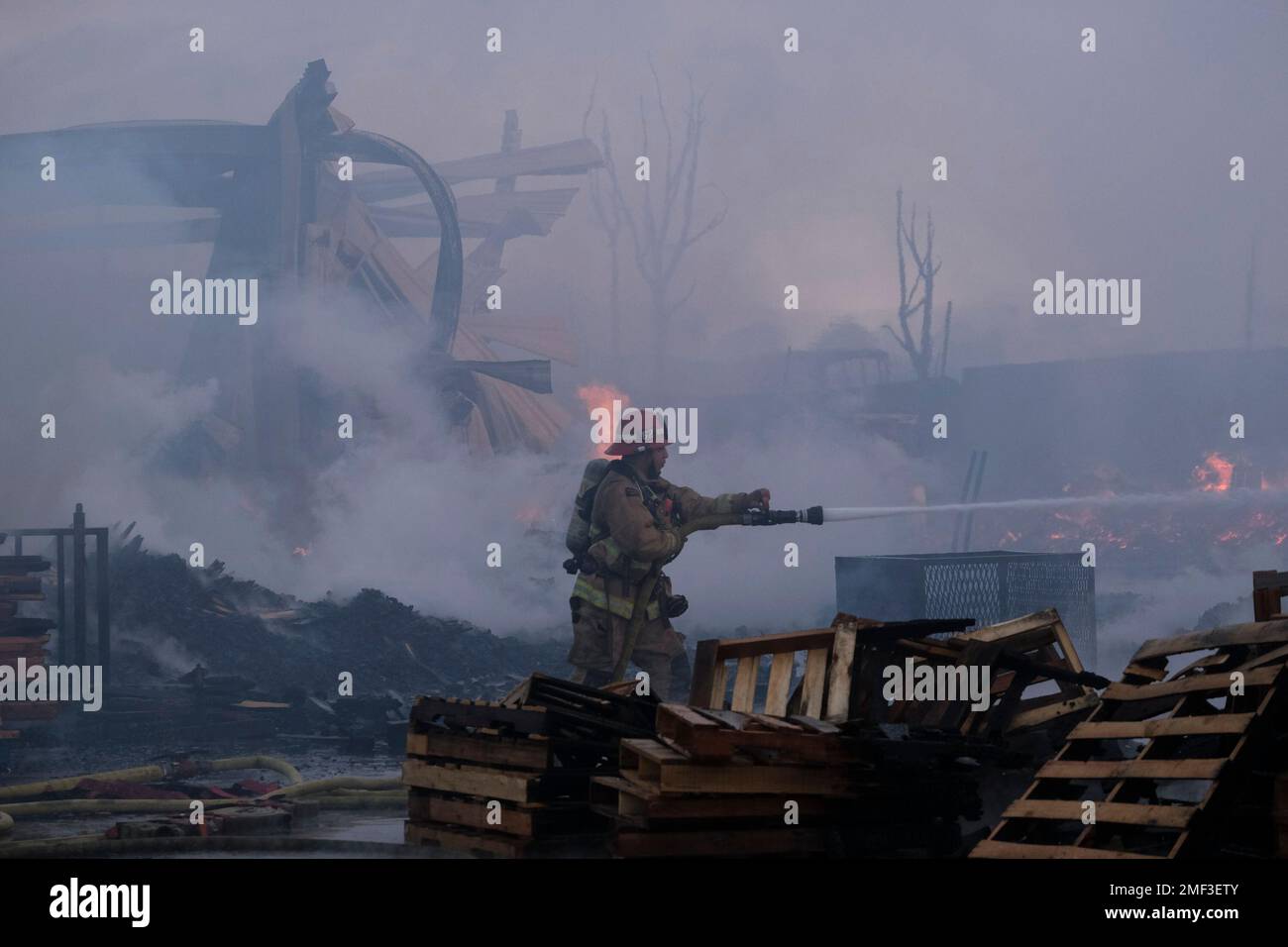 A firefighter battles a fire at a commercial yard in Compton, Calif ...