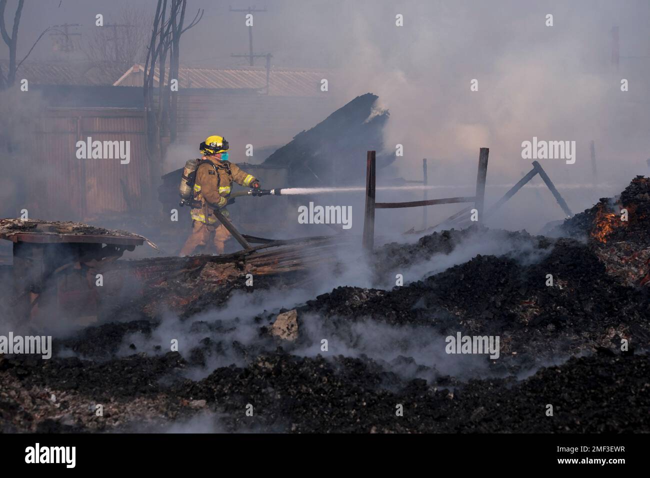A firefighter battles a fire at a commercial yard in Compton, Calif ...