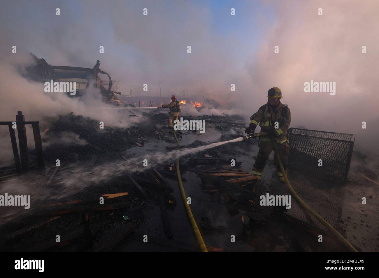 Firefighters battle a fire at a commercial yard in Compton, Calif., on ...
