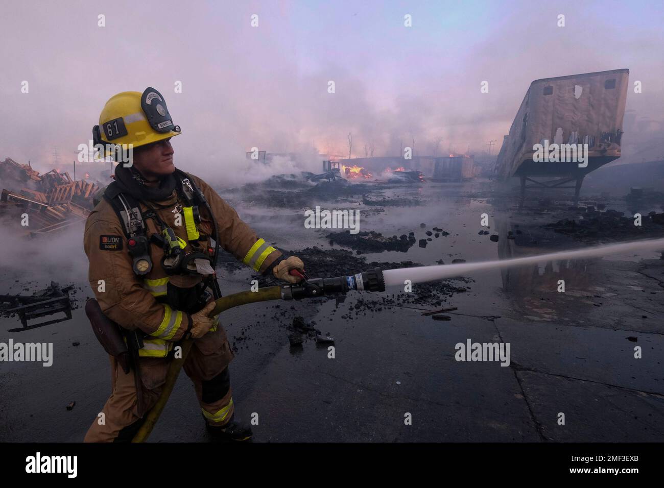 A firefighter battles a fire at a commercial yard in Compton, Calif ...