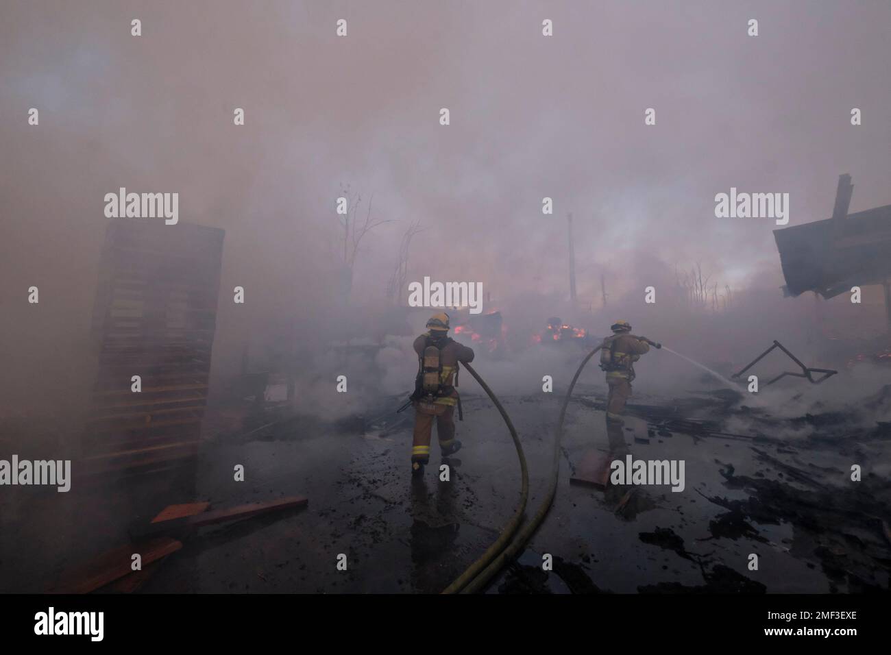 Firefighters battle a fire at a commercial yard in Compton, Calif., on ...