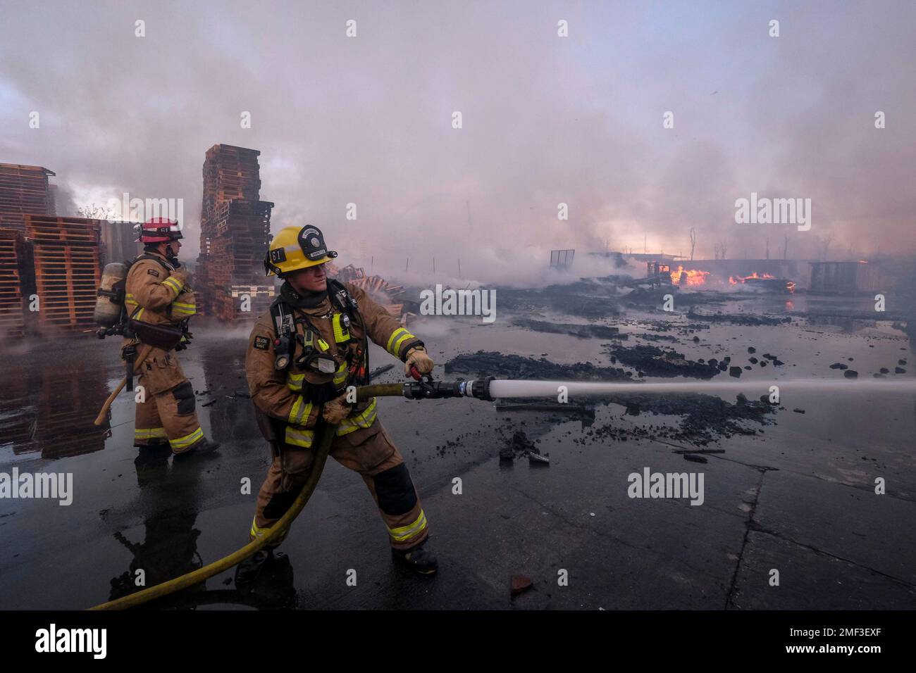Firefighters battle a fire at a commercial yard in Compton, Calif., on ...