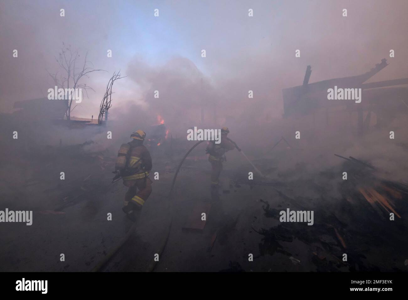 Firefighters battle a fire at a commercial yard in Compton, Calif., on ...
