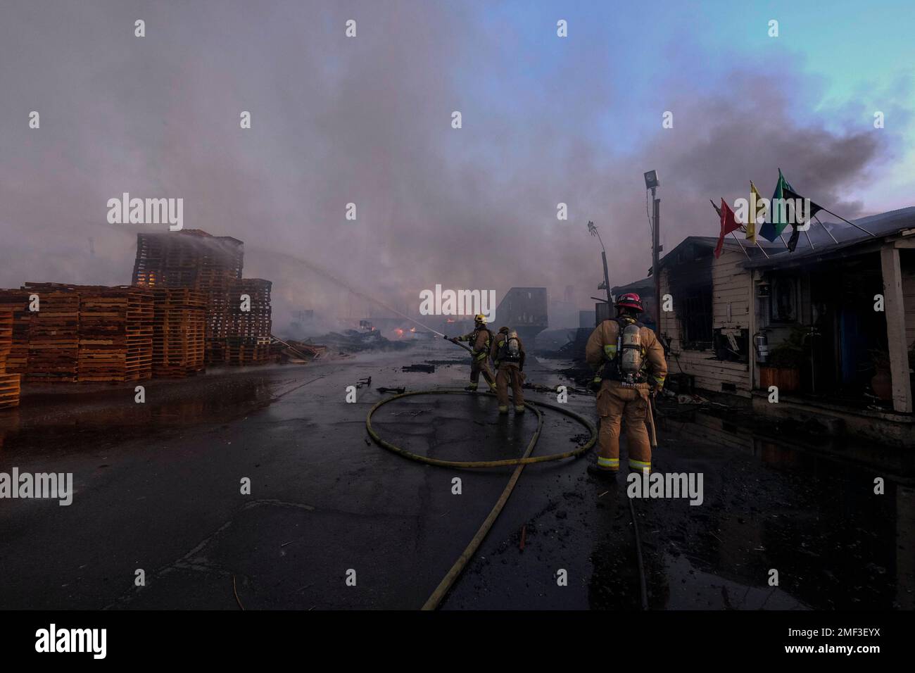 Firefighters battle a fire at a commercial yard in Compton, Calif., on ...