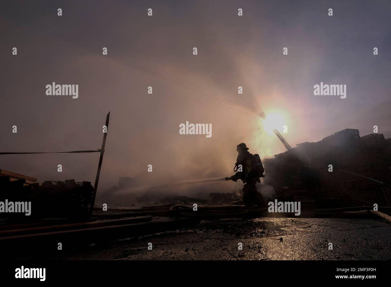 A firefighter battles a fire at a commercial yard in Compton, Calif ...