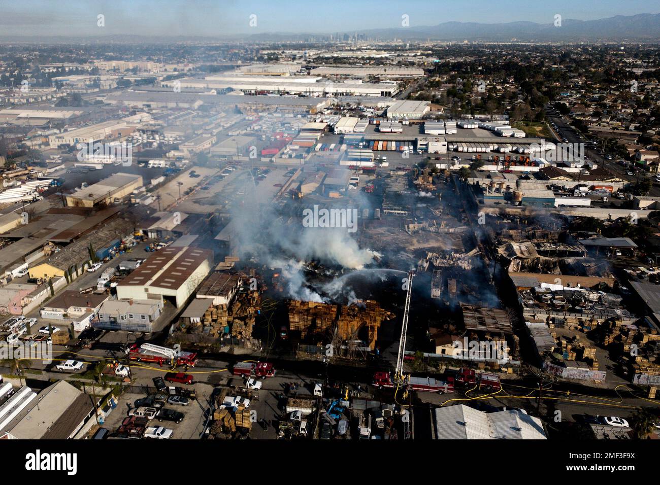 In this photo taken by a drone, firefighters battle a fire at a ...