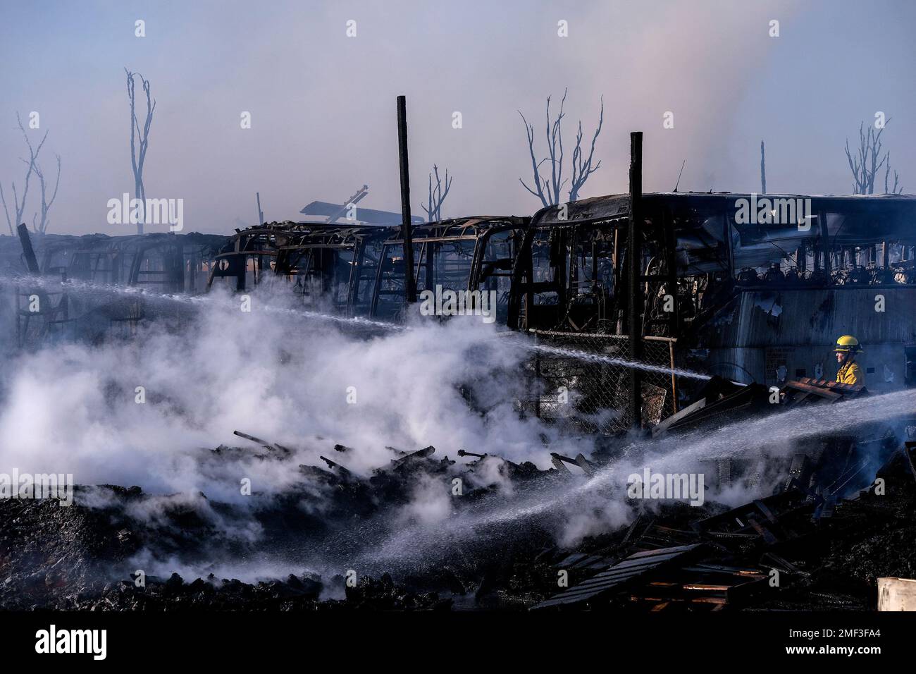A firefighter battles a fire at a commercial yard in Compton, Calif ...