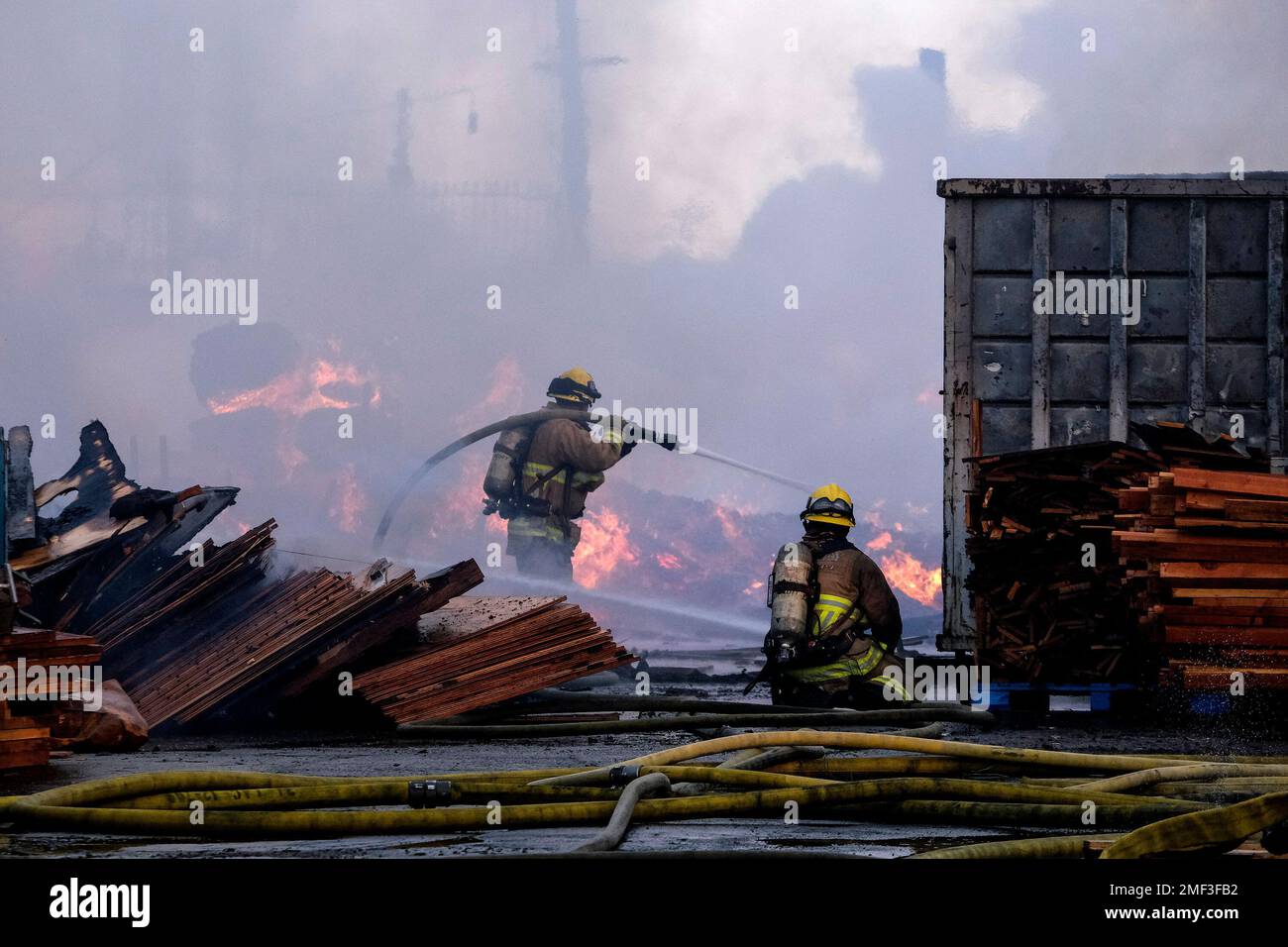Firefighters battle a fire at a commercial yard in Compton, Calif., on ...