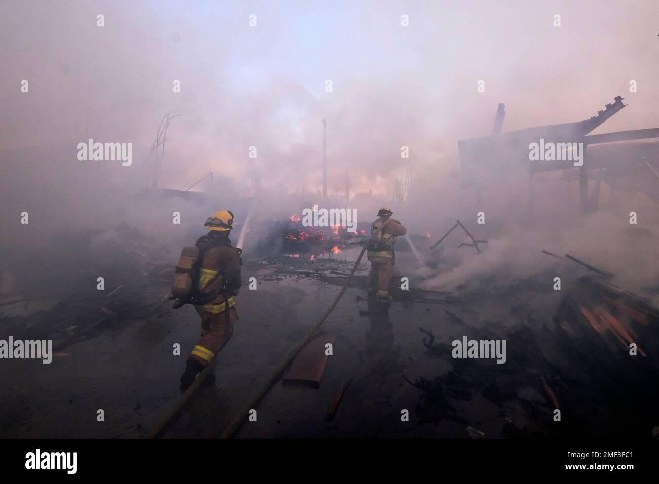 Firefighters battle a fire at a commercial yard in Compton, Calif., on ...