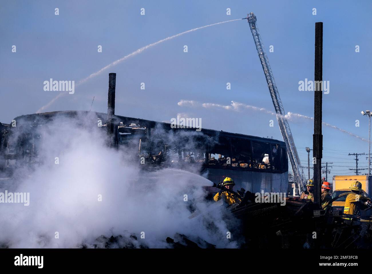 Firefighters battle a fire at a commercial yard in Compton, Calif., on ...