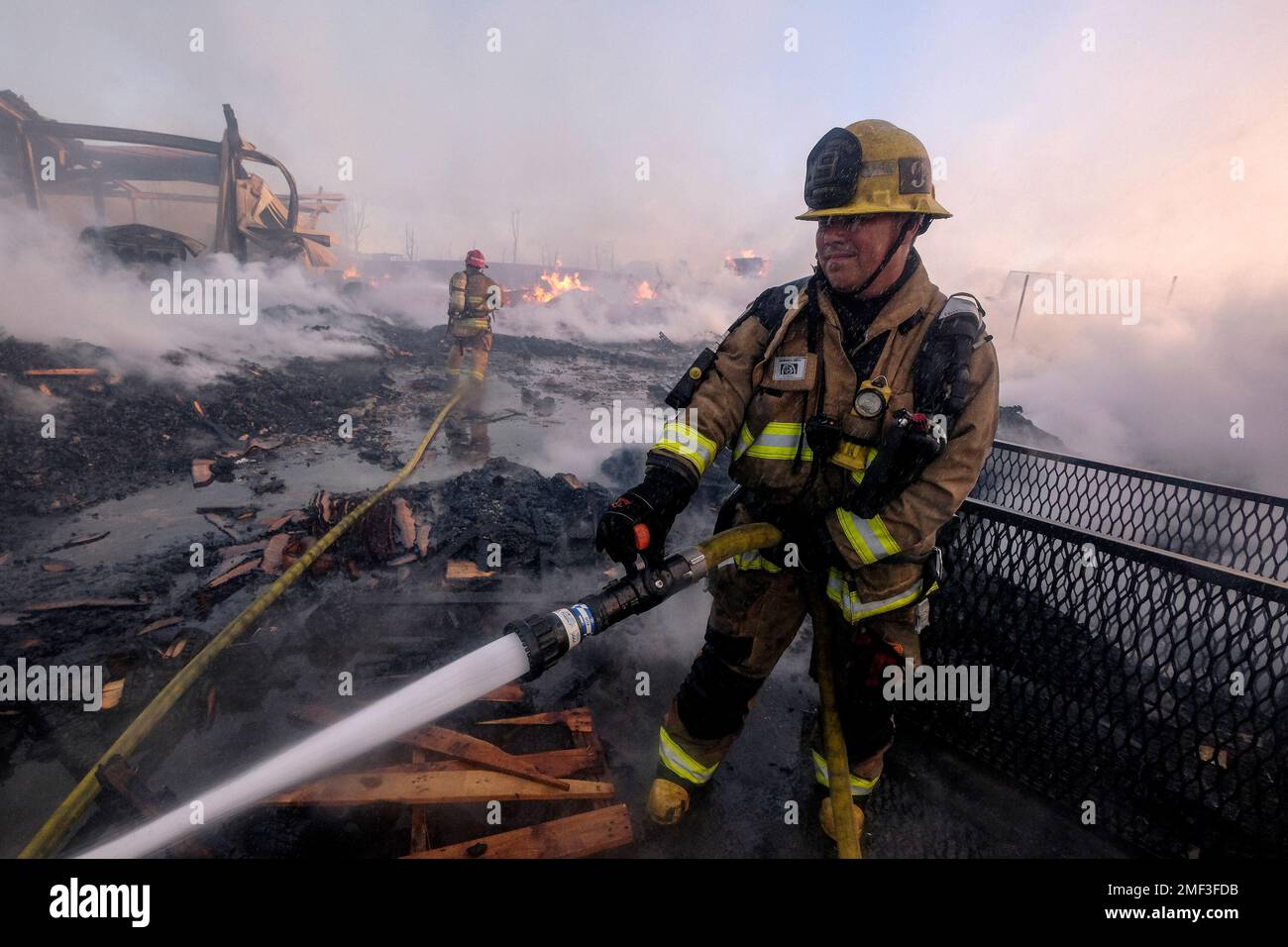Firefighters battle a fire at a commercial yard in Compton, Calif., on ...