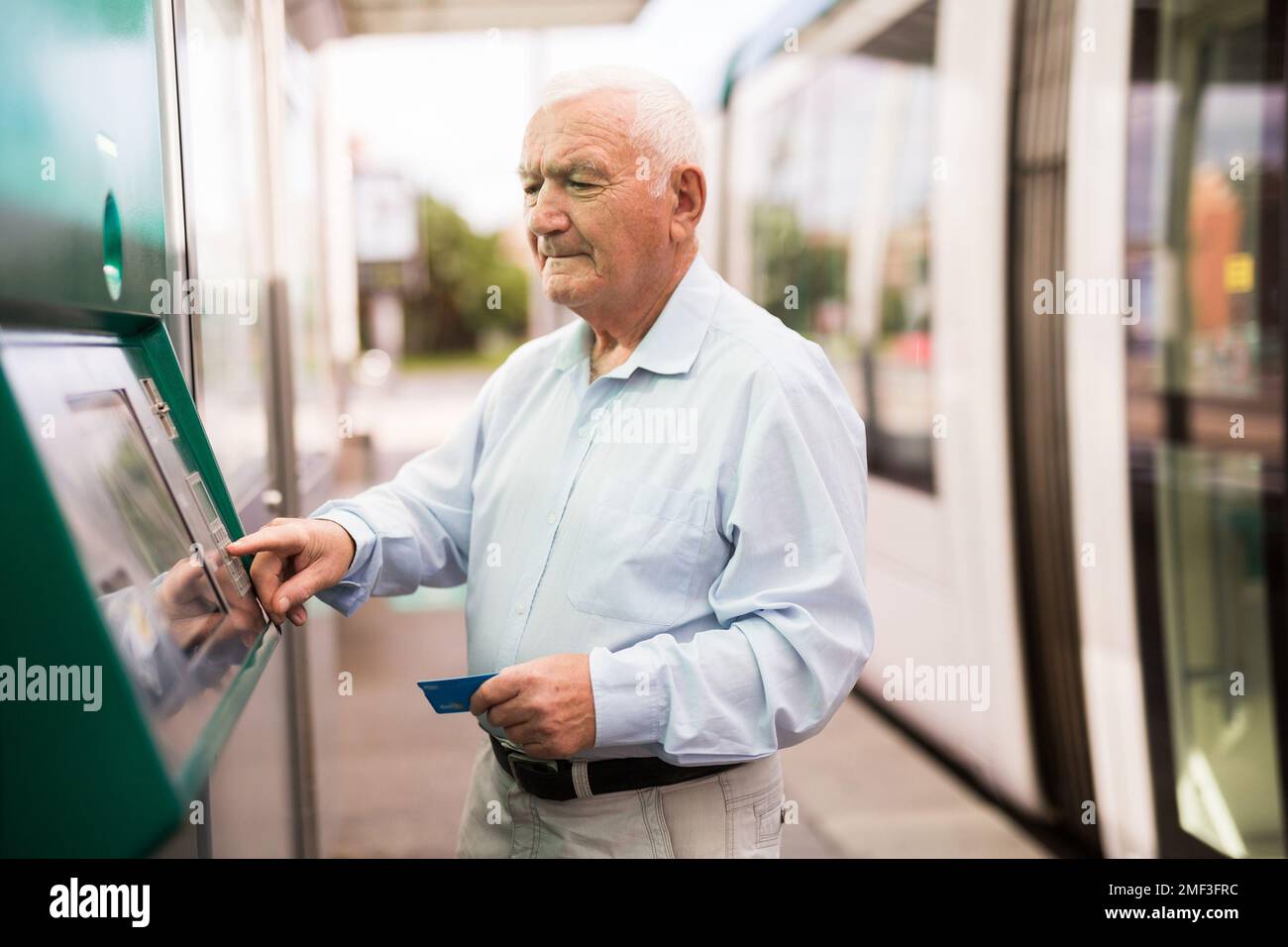 Elderly man using cash machine Stock Photo - Alamy