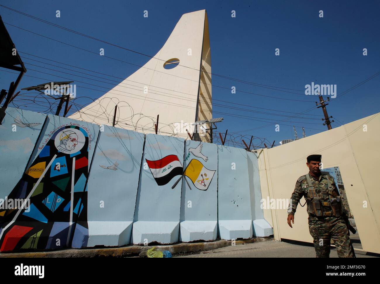 An Iraqi army soldier stands guard by a concrete wall placed by Iraqi ...