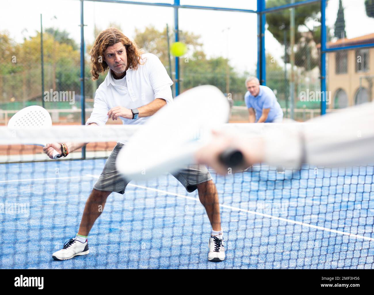 Sporty resolved man playing padel on open court Stock Photo - Alamy
