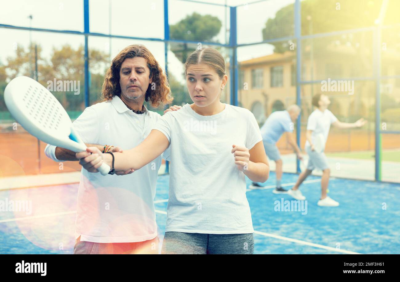 Paddle tennis instructor giving lessons to girl Stock Photo - Alamy