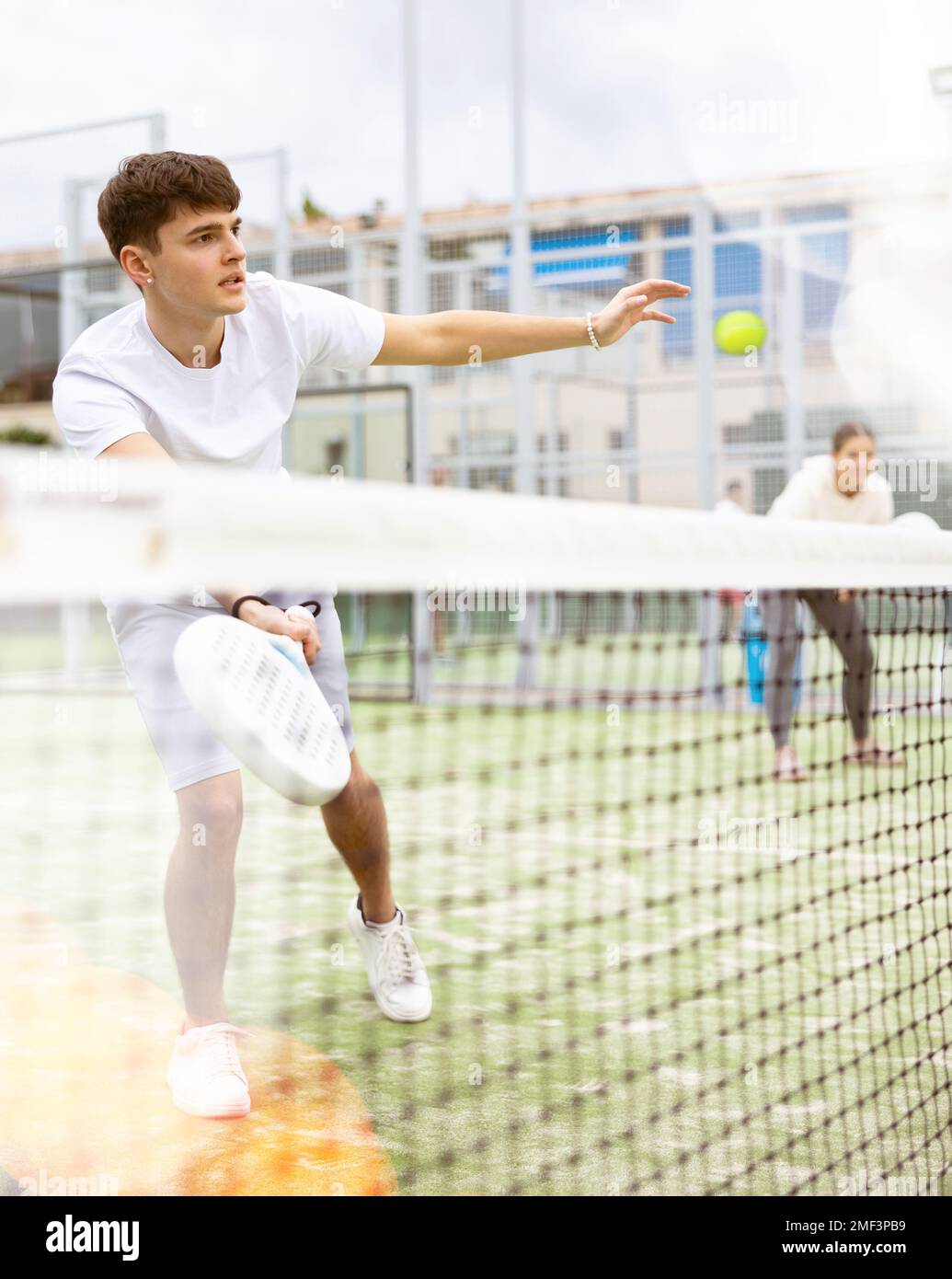 Sporty young guy playing padel on open court Stock Photo - Alamy