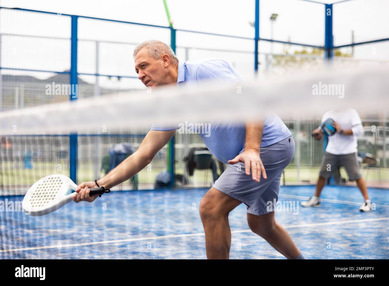 Aged man playing paddleball match on outdoor court Stock Photo - Alamy