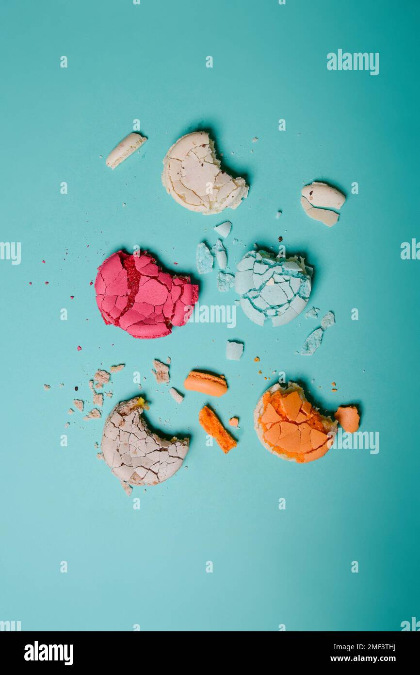 Crushed, broken macaron, French colored dessert on a blue background ...