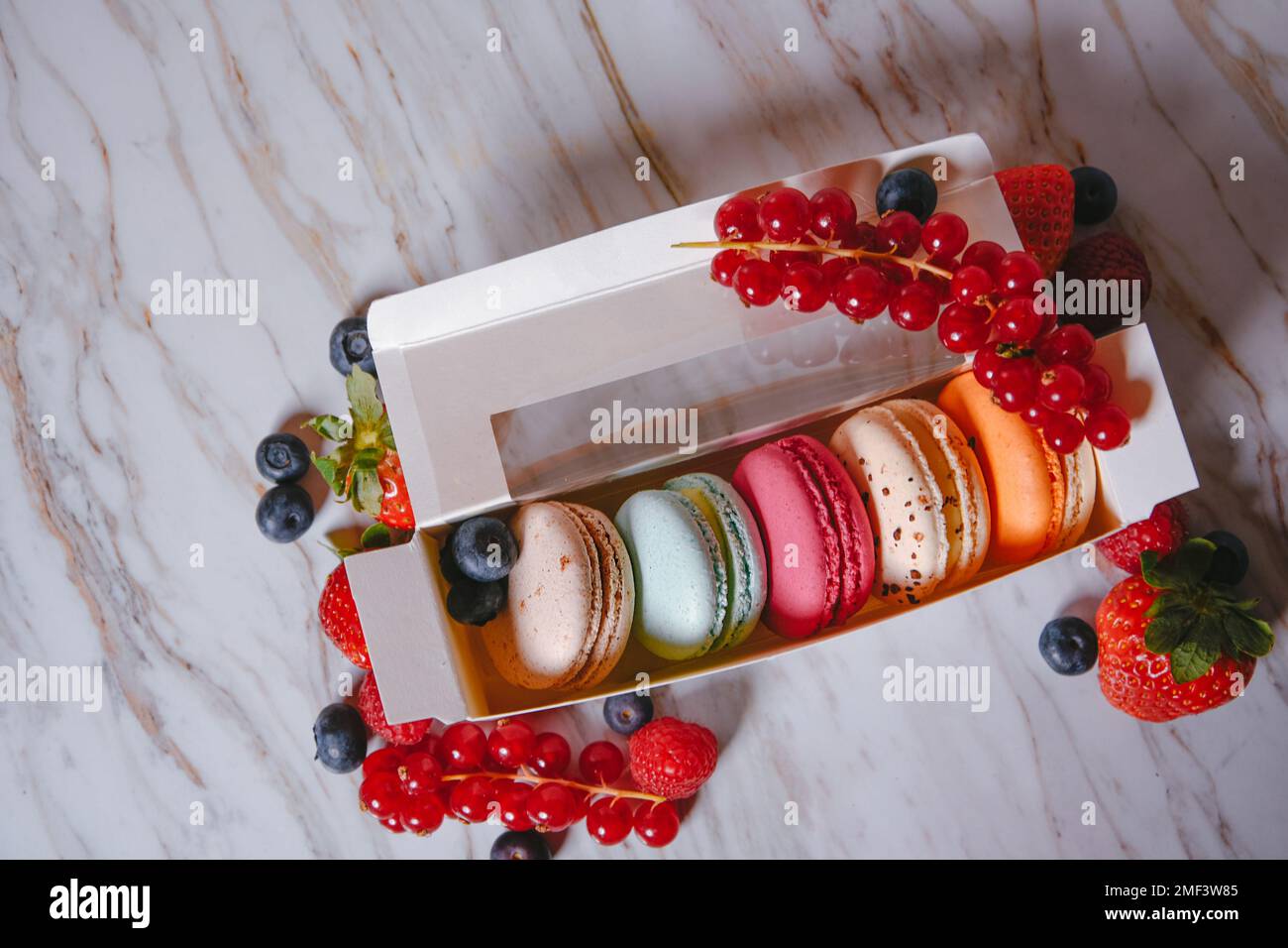 Macaronis in a white box with a transparent window. Color dessert, pink ...