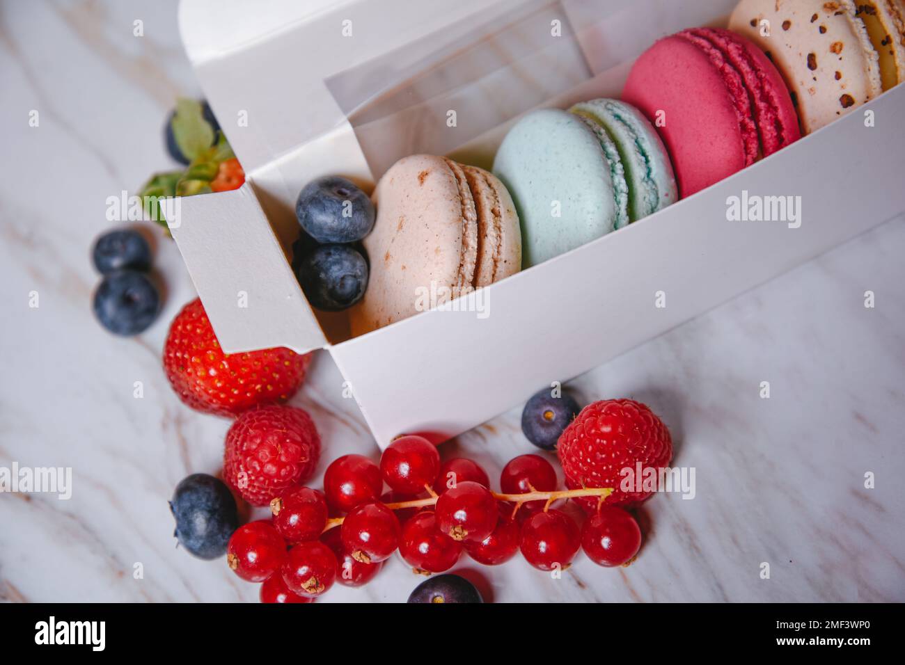 Macaronis in a white box with a transparent window. Color dessert, pink ...