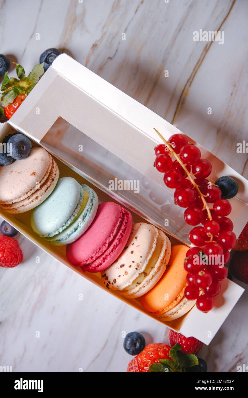 Macaronis in a white box with a transparent window. Color dessert, pink ...