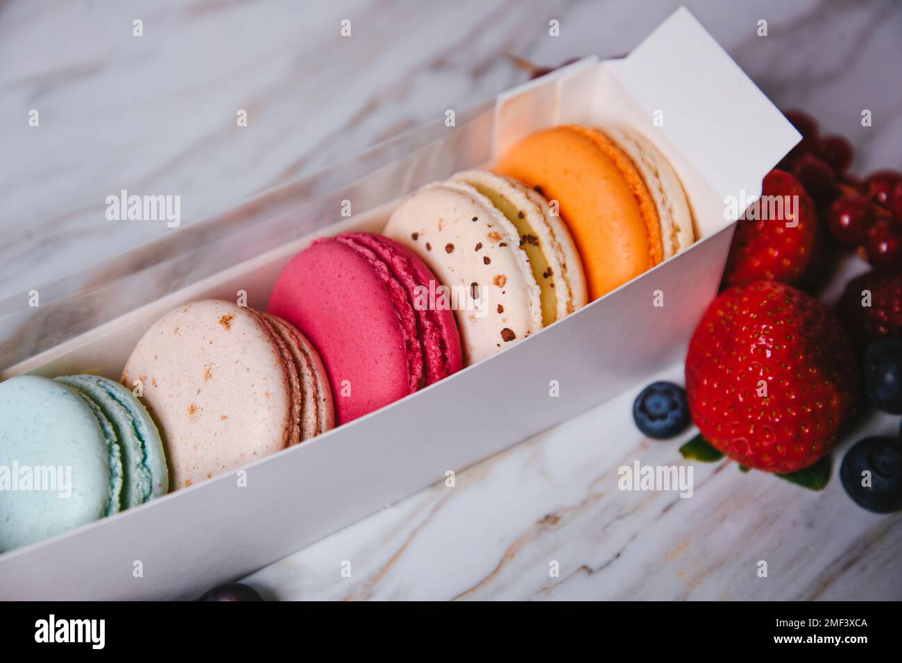Macaronis in a white box with a transparent window. Color dessert, pink ...