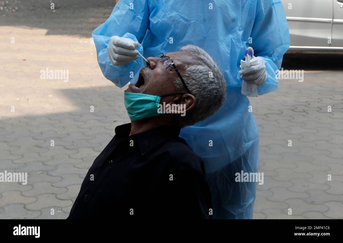 A health worker collects nasal swab during door to door screening for ...