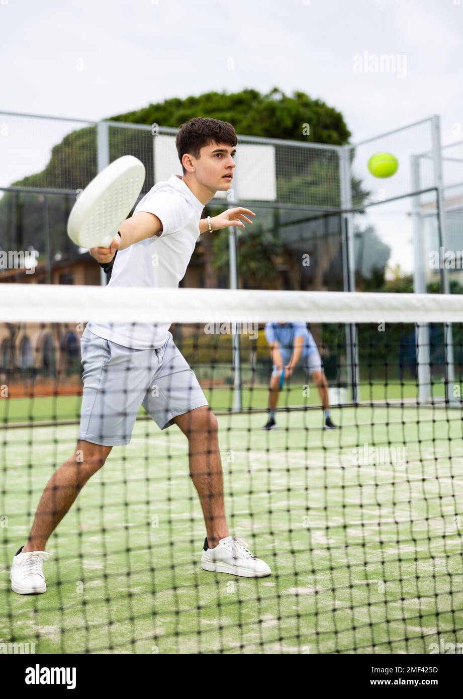 View through tennis net of an young playing padel Stock Photo - Alamy