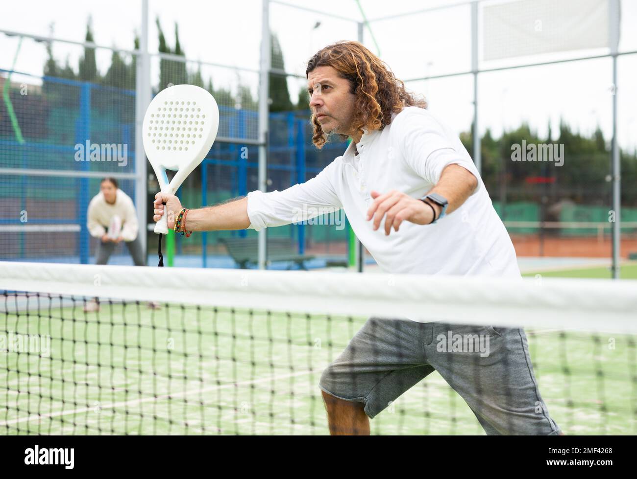 Focused adult man playing paddle tennis outdoors Stock Photo - Alamy
