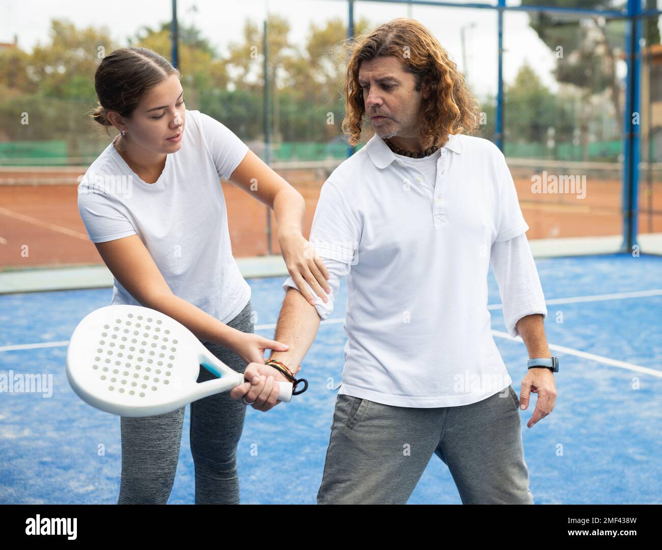 Portrait of female trainer teaching man playing padel Stock Photo - Alamy