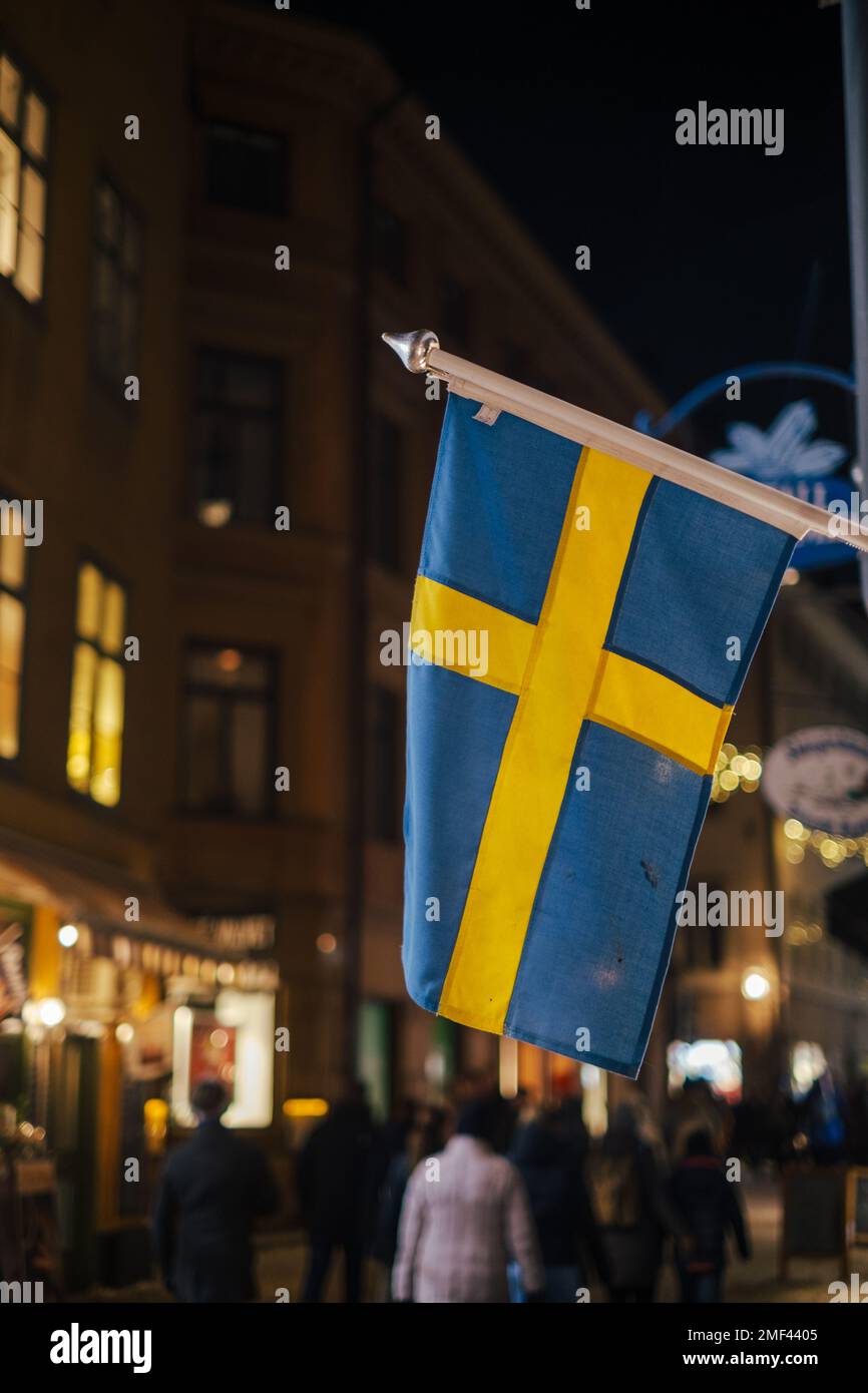 A Swedish flag hanging outside a shop in Stockholm Stock Photo - Alamy