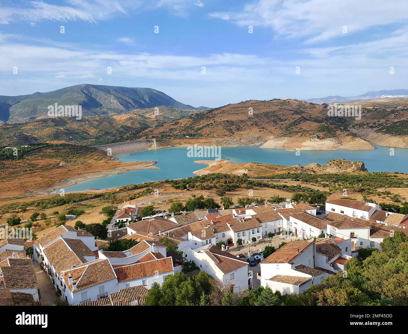 A drone shot of houses on the coast of a lake in Zahara de la Sierra ...