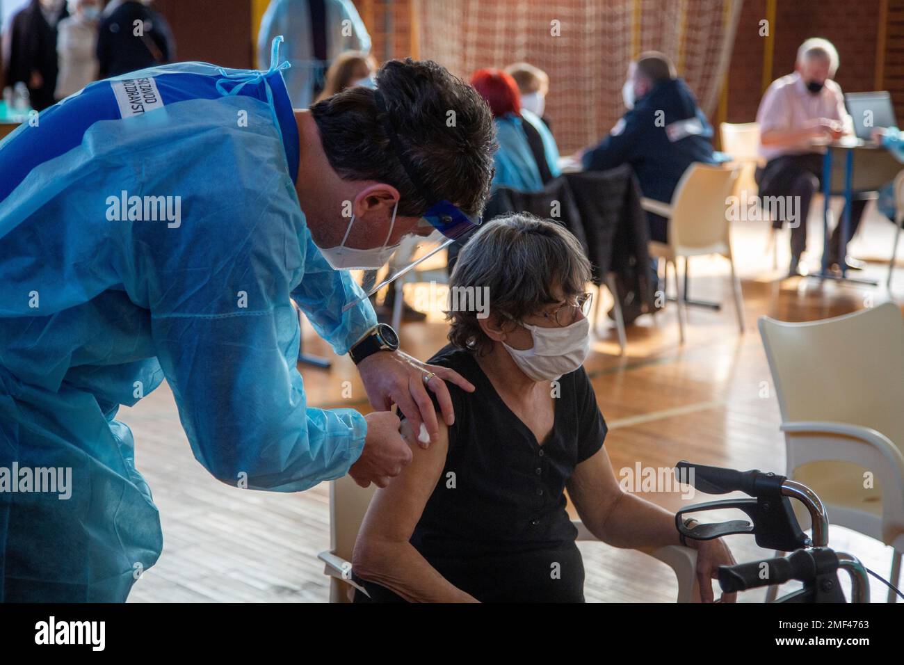 An elderly lady receives a Pfizer coronavirus vaccine at a sports hall ...