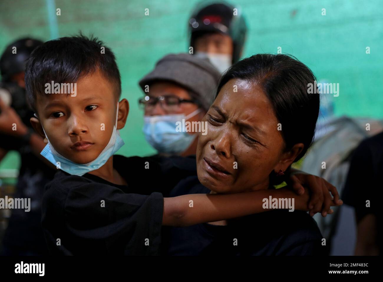 Thida Hnin, right, wife of Thet Naing Win, weeps as her son Aung Phone ...