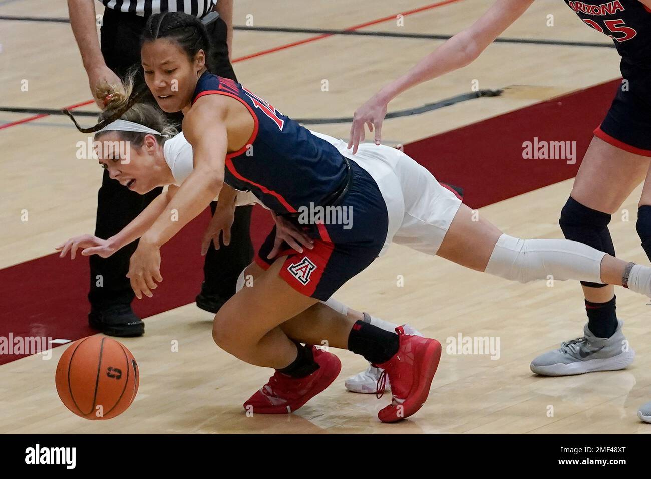 Arizona forward Sam Thomas, foreground, reaches for the ball in front ...