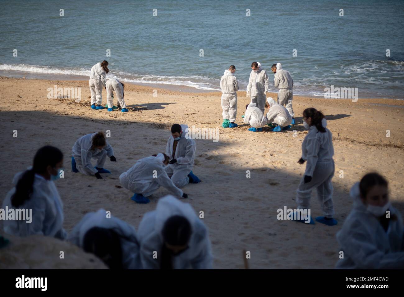 Israeli soldiers wearing protective suits clean tar from a beach after ...