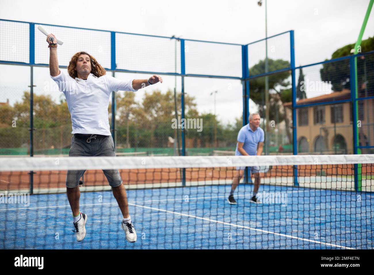 Focused man playing paddleball match on outdoor court Stock Photo - Alamy