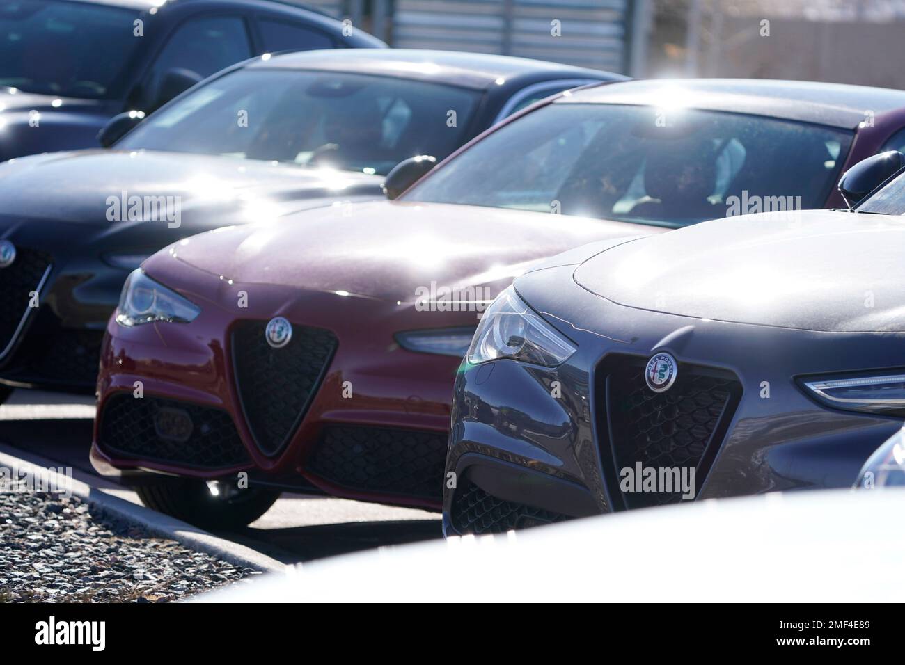 A long line of unsold 2021 vehicles sits at an Alfa Romeo dealership ...