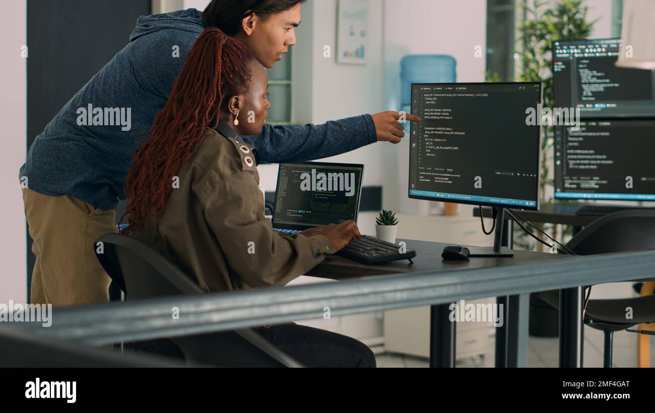 Two Software Coders Analyzing Source Code On Computer And Laptop Screen Using Html Script On