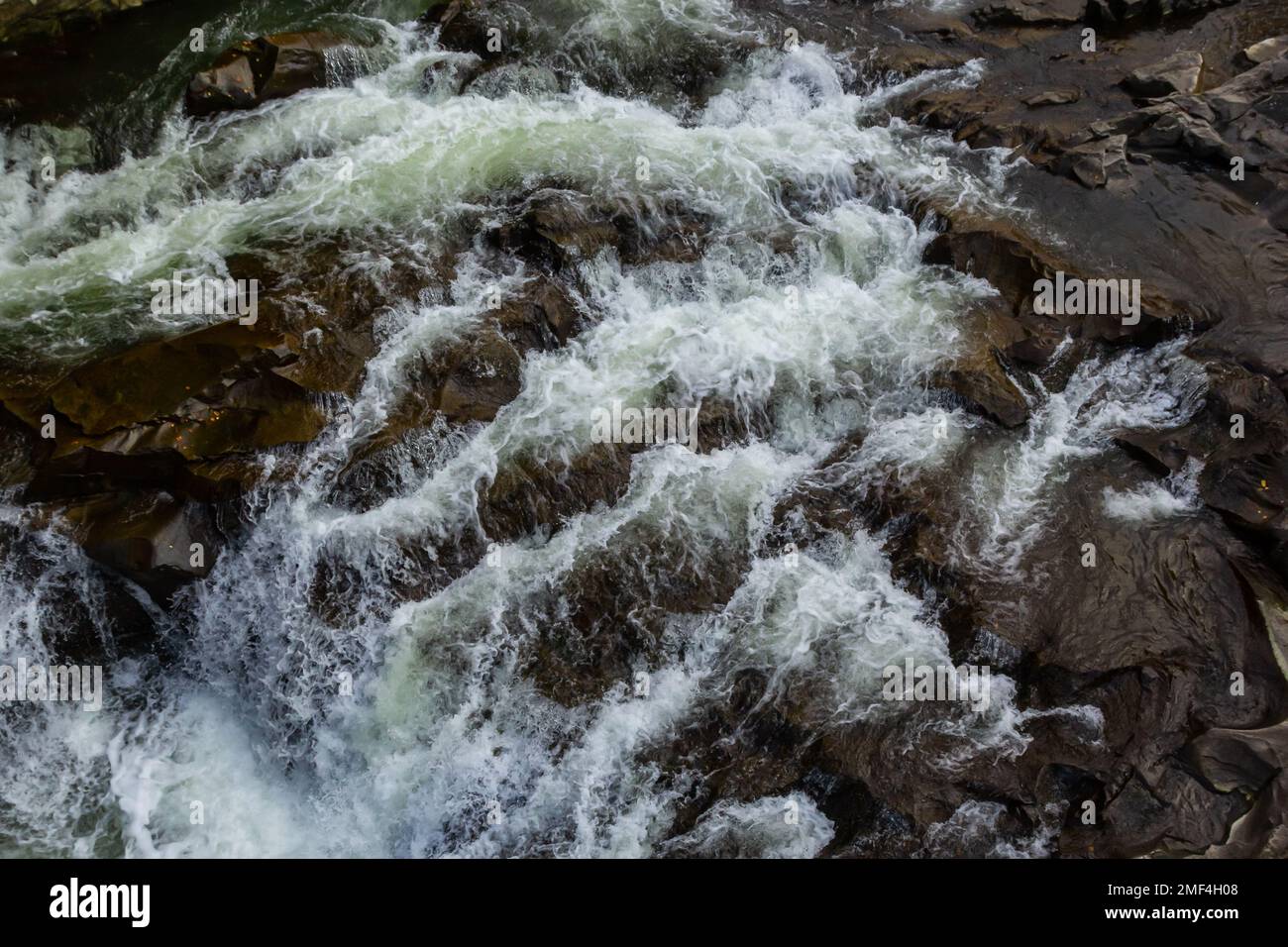 rapids of mountain rivers with fast water and large rocky boulders ...