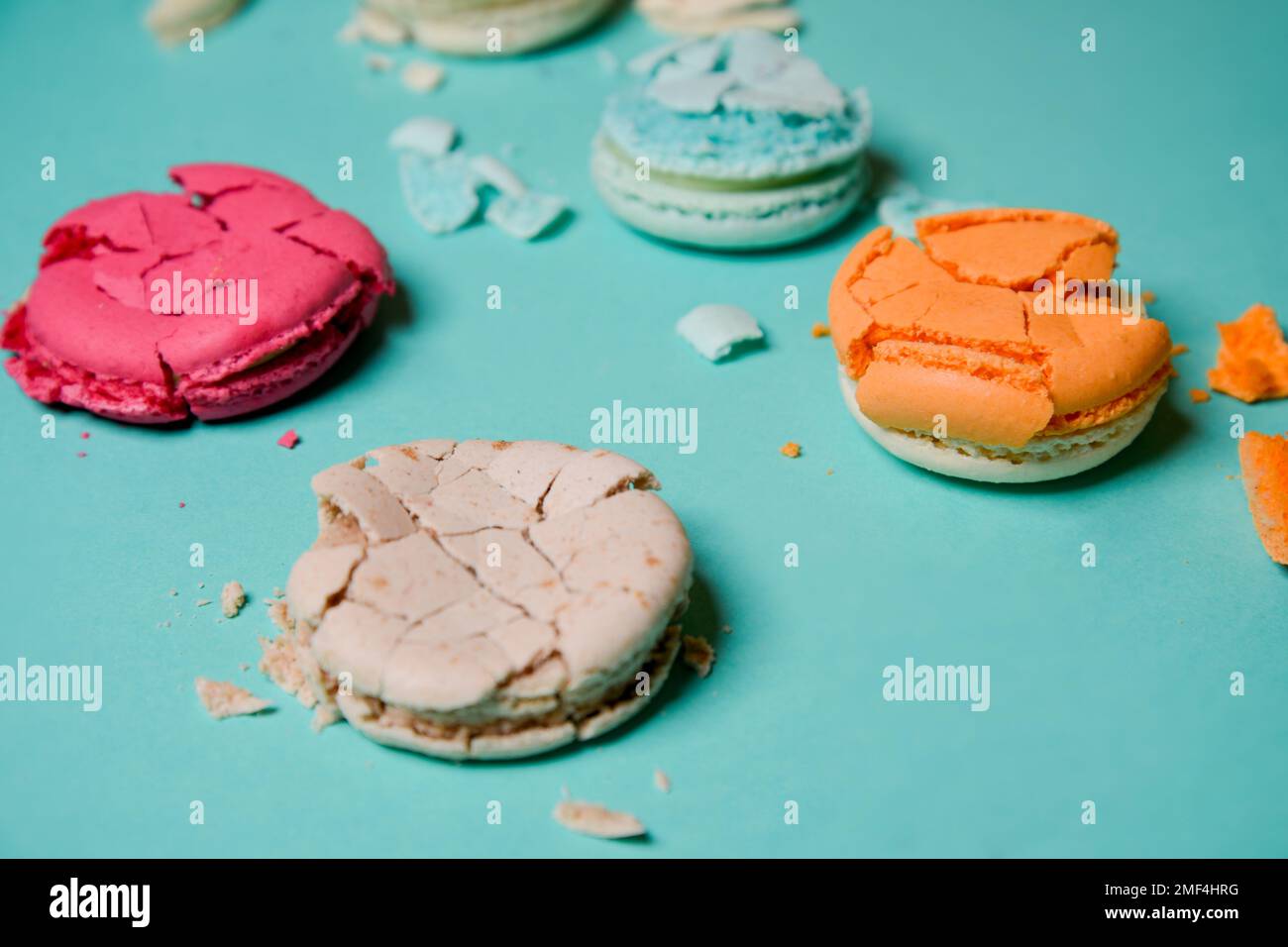 Crushed, broken macaron, French colored dessert on a blue background ...