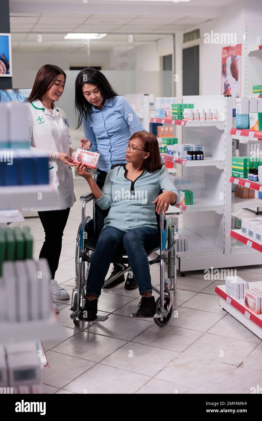 Medical assistant helping client with physical disability, talking to ...