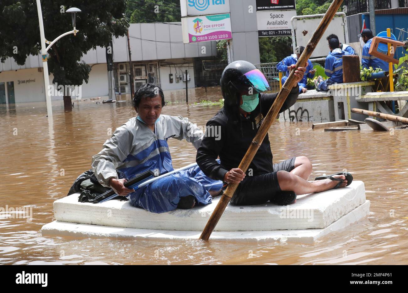 Residents use a cork material as a raft to make their way through a ...
