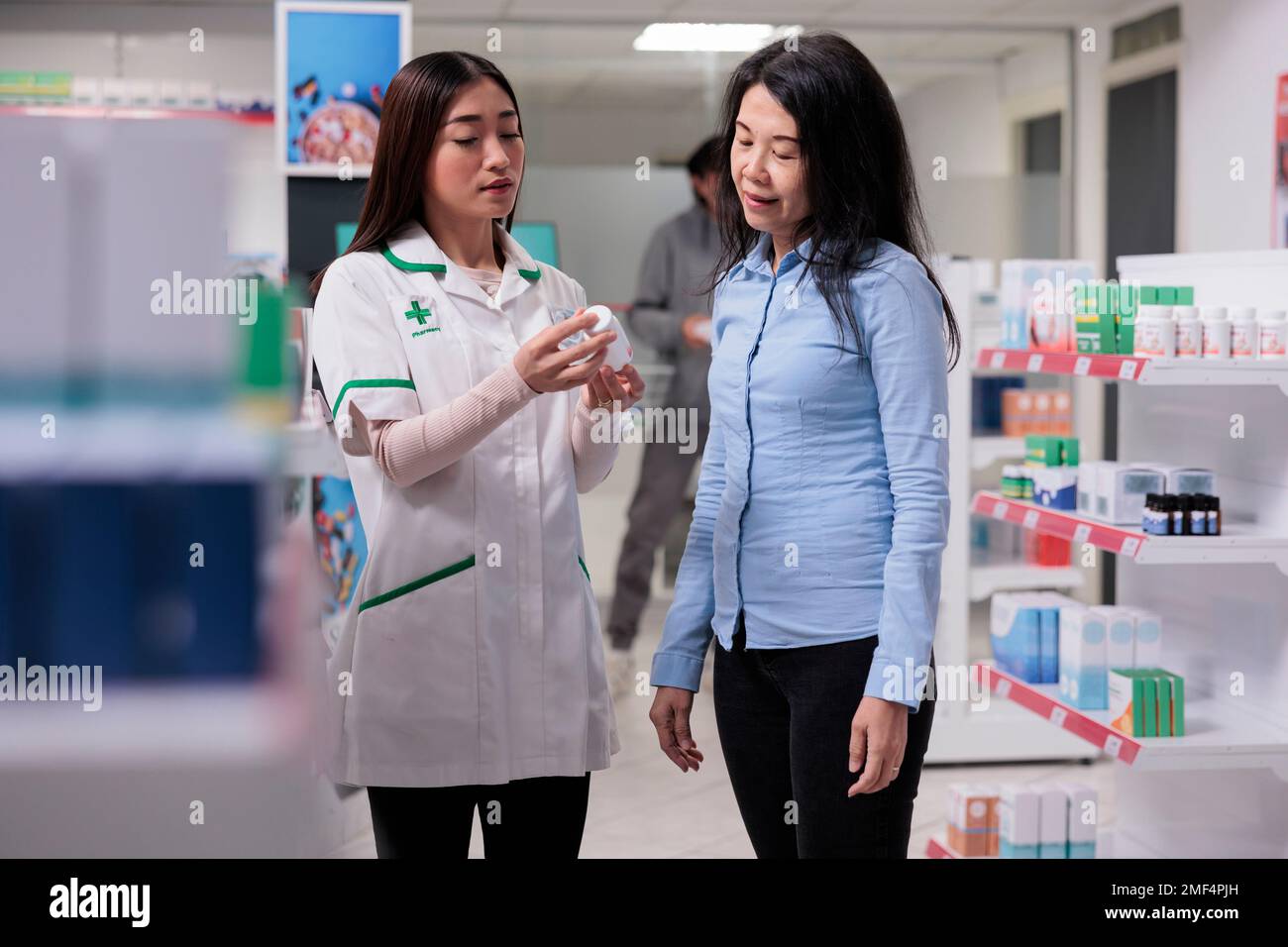 Asian healthcare worker helping customer with medicaments, recommending ...