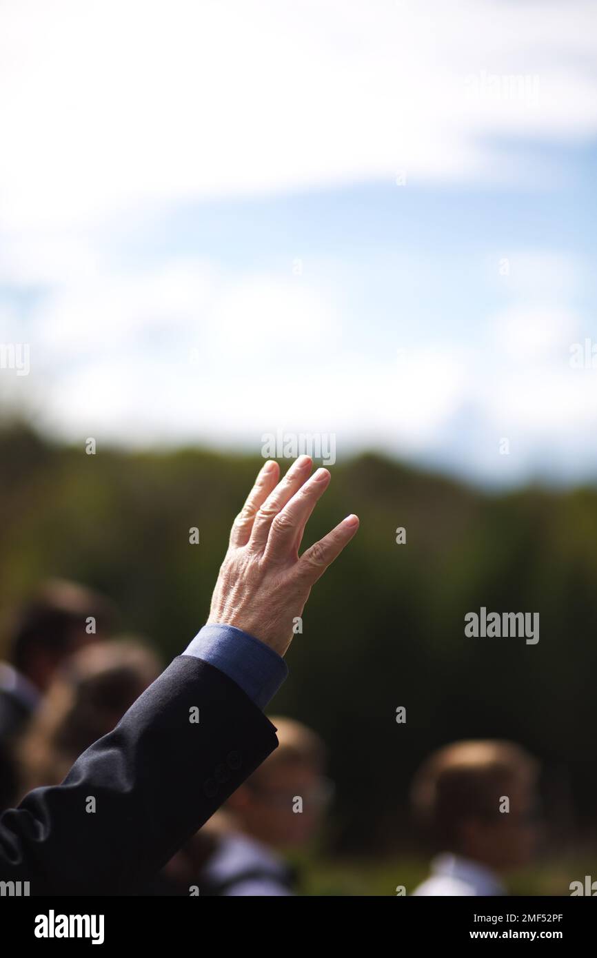 A vertical shot of a man's hand raised up against blur background Stock ...