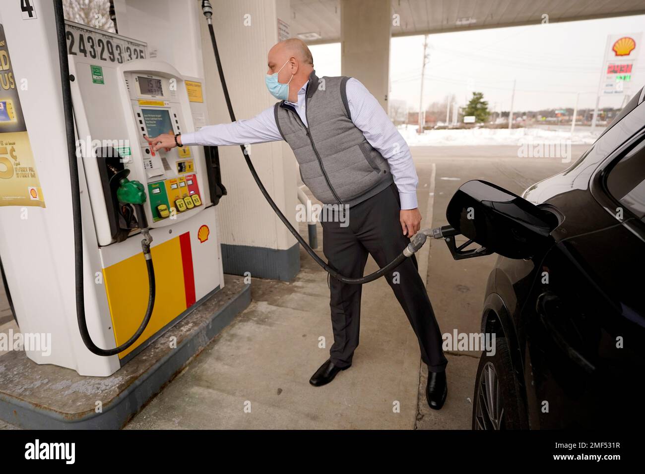 Jeremy Heskett, of Boston, prepares to pour gasoline at a Shell gas ...