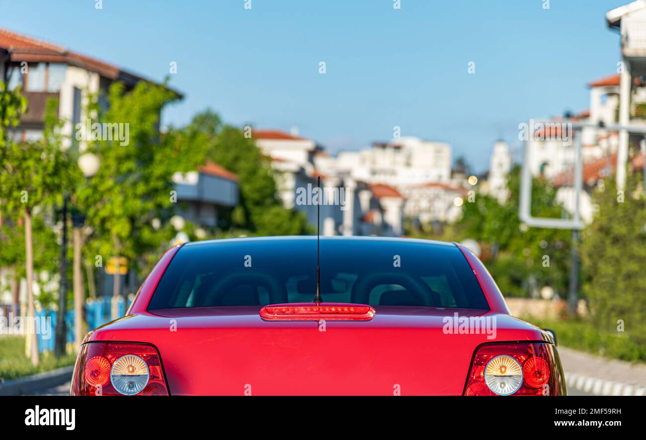 Red car on a city street Stock Photo - Alamy